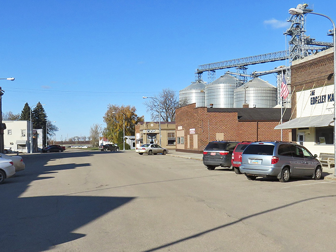 Main Street Edgeley, where those silver grain elevators aren't just functional landmarks&mdash;they're the town's version of skyscrapers against that impossibly blue Dakota sky.