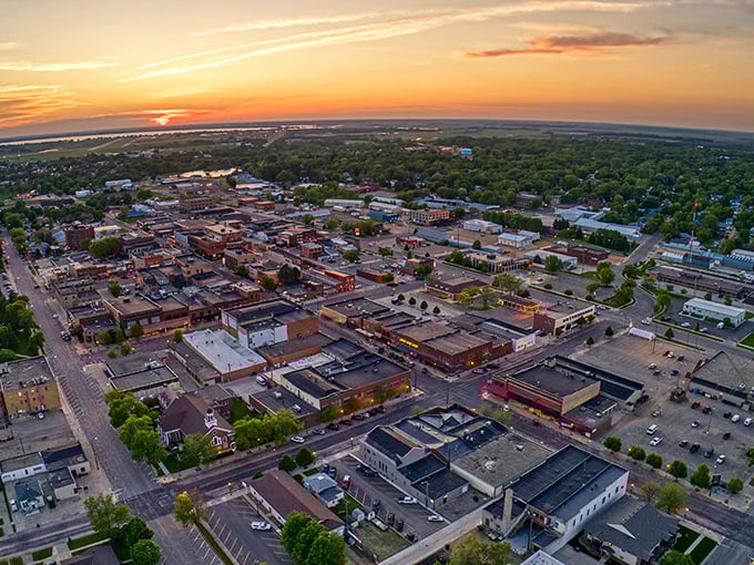 Watertown's sunset skyline offers a golden farewell to the day, with downtown buildings basking in warm light while nature surrounds this charming South Dakota gem.