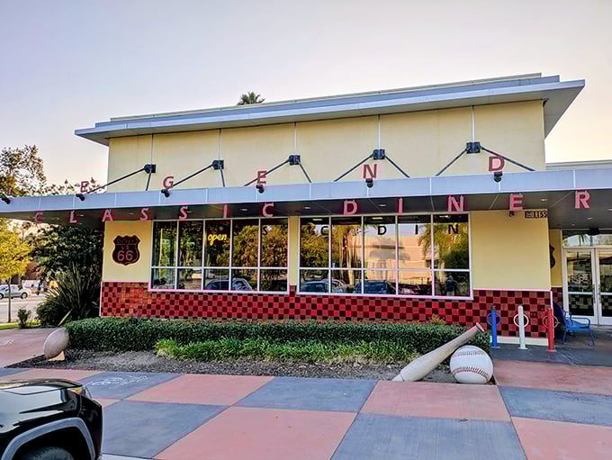 Sunset casts a golden glow on Legends' angular roofline and checkerboard trim&mdash;pure mid-century magic that promises delicious nostalgia inside.