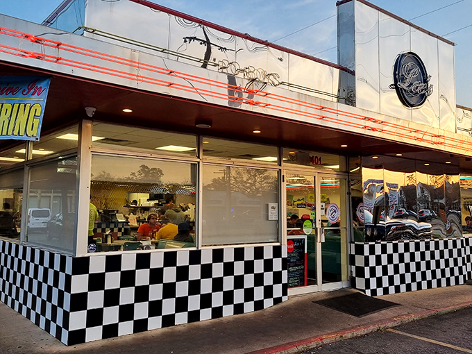 Golden hour bathes Lee's Diner in warm light, highlighting its vintage neon trim and welcoming checkered pattern that beckons hungry travelers.
