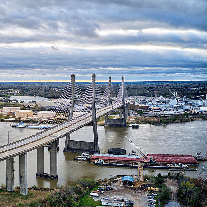 Mobile's stunning Cochrane Bridge spans the river like a steel necklace, connecting communities while barges navigate the lifeblood waterway below.