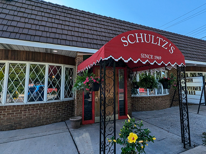 The iconic red entrance awning promises authentic Maryland seafood traditions behind those doors, with "steamed crabs" advertised proudly.