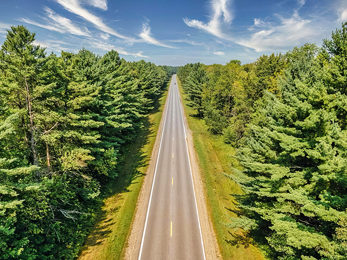 Nature's perfect corridor stretches to the horizon, where towering pines stand like sentinels guarding Minnesota's most mesmerizing highway. This is road trip therapy at its finest.