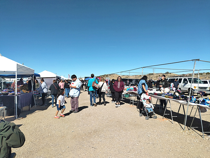 Families stroll through dusty aisles under brilliant blue skies, hunting for treasures at this legendary Saturday gathering.