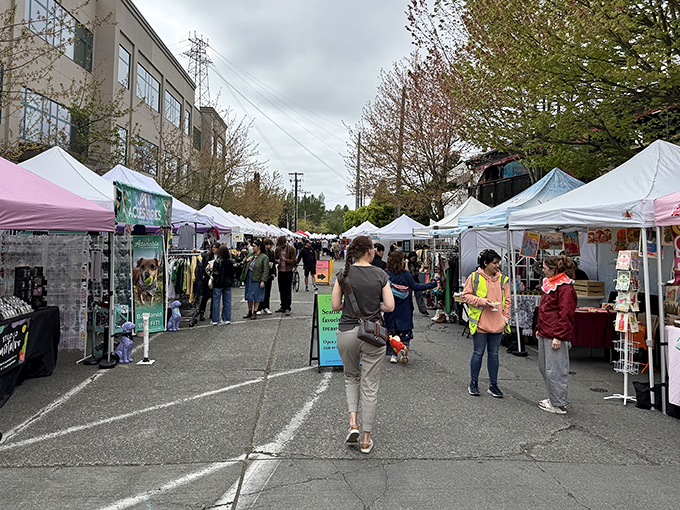 A bustling avenue of white tents where Seattle's treasure hunters navigate between artisan stalls, each one a portal to unexpected discoveries.