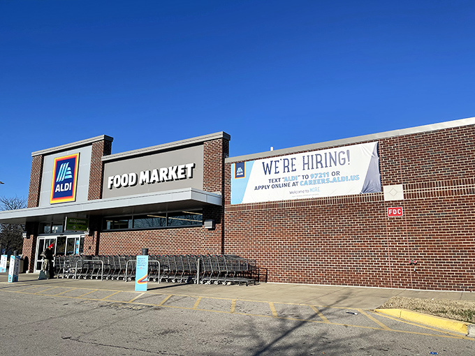 ALDI's "We're Hiring" banner flutters in the Kentucky breeze &ndash; a reminder that behind every quarter-deposit cart is a team of scanning speed demons.