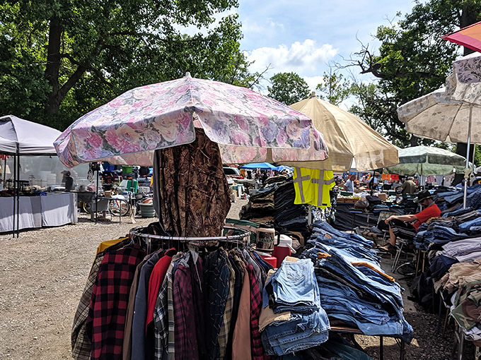 Floral umbrellas shade racks of flannel shirts and denim at this bustling outdoor market.