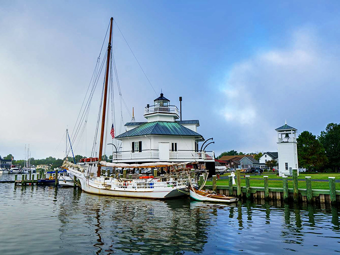 The historic Hooper Strait Lighthouse at the Chesapeake Bay Maritime Museum stands sentinel as sailboats dock along Saint Michaels' peaceful waterfront.