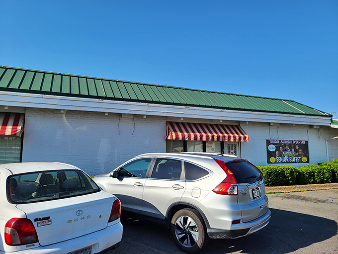 Red and white awnings beckon hungry travelers like a lighthouse for comfort food seekers. The full parking lot tells the real story.