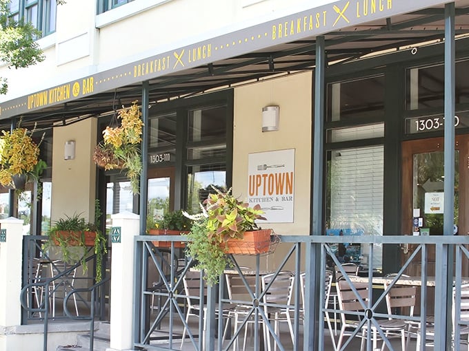 The welcoming storefront of Uptown Kitchen & Bar beckons with its cheerful yellow signage and lush greenery. A culinary oasis in Jacksonville's urban landscape.
