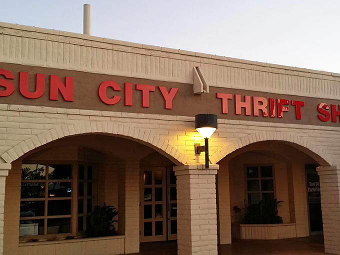 The iconic Sun City Thrift Shop sign glows warmly against the Arizona sky, beckoning bargain hunters like a desert mirage that actually delivers.