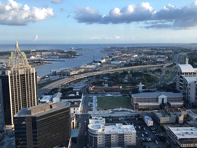 The RSA Battle House Tower pierces the skyline like a crown jewel, overlooking Mobile Bay where ships have sailed for centuries.