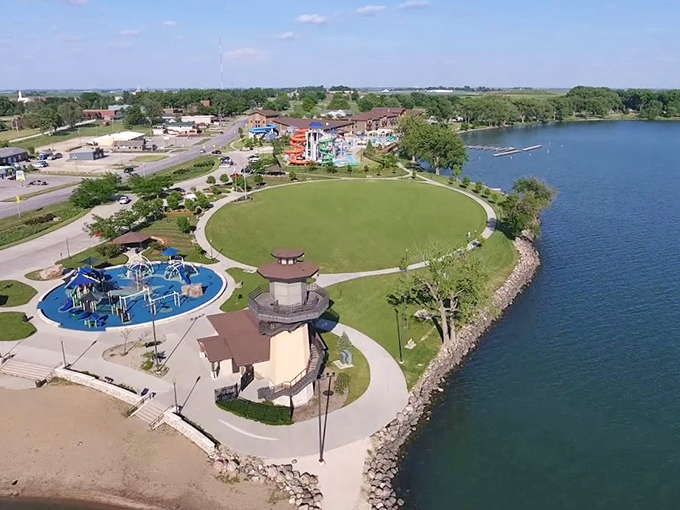 Aerial view of Storm Lake's waterfront park showcasing the perfect trifecta: a lighthouse tower, splash pad for the kids, and enough green space to host a small country fair.