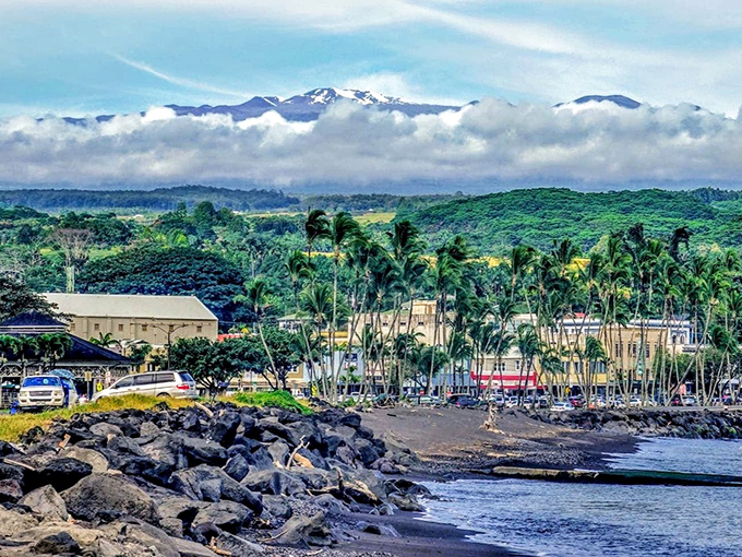 Mauna Kea plays peekaboo through the clouds as palm trees sway along Hilo's rocky shoreline &ndash; nature's perfect backdrop for treasure hunting adventures.