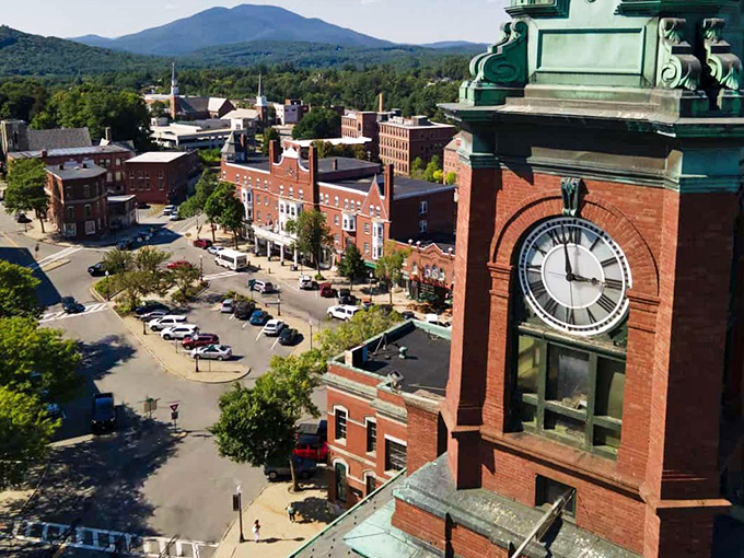 Claremont's downtown vista showcases its iconic clock tower standing sentinel over red brick buildings, with mountains creating a backdrop worthy of a New England postcard.