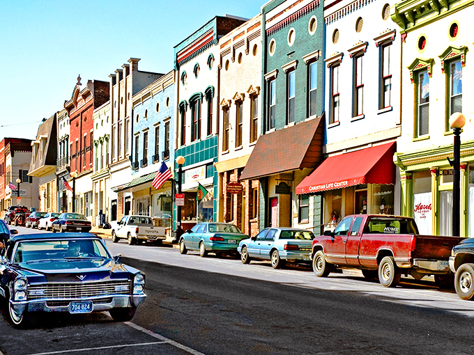 Colorful historic storefronts line Main Street, where vintage cars meet small-town charm in this picturesque downtown scene.