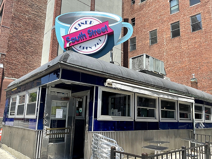 The iconic blue exterior and giant coffee cup sign of South Street Diner stands as a beacon of hope for hungry night owls in Boston's Leather District.