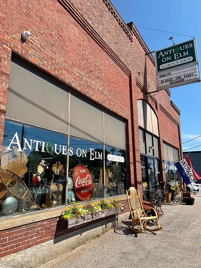 The classic brick exterior of Antiques on Elm beckons with promises of treasures waiting inside. That rocking chair isn't just sitting there&mdash;it's inviting you in.