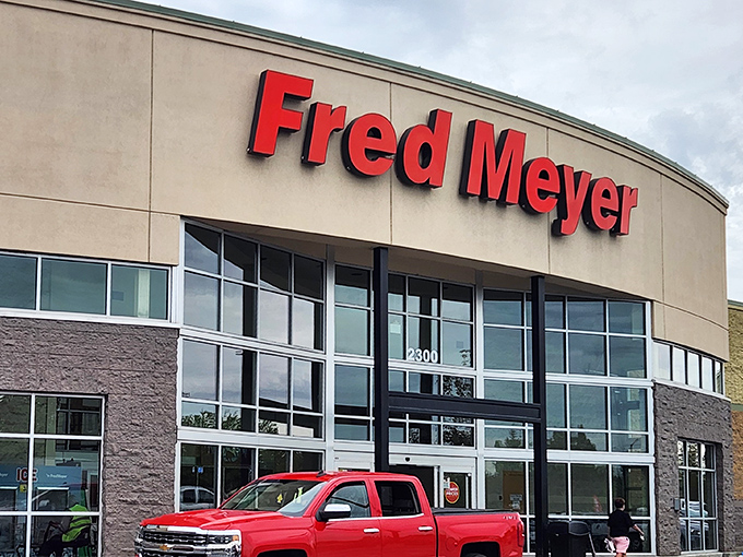 The iconic red Fred Meyer sign welcomes Alaskans like a beacon of retail hope against the often-gray Anchorage sky. Shopping adventure begins here!