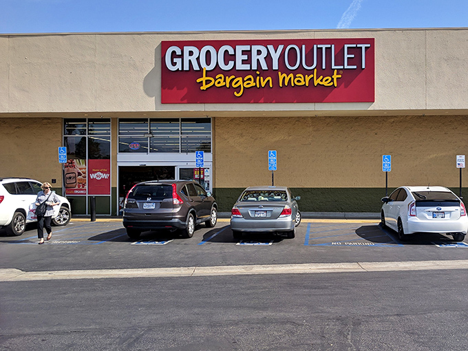 The iconic red Grocery Outlet sign beckons like a lighthouse for bargain hunters navigating the stormy seas of California grocery prices.