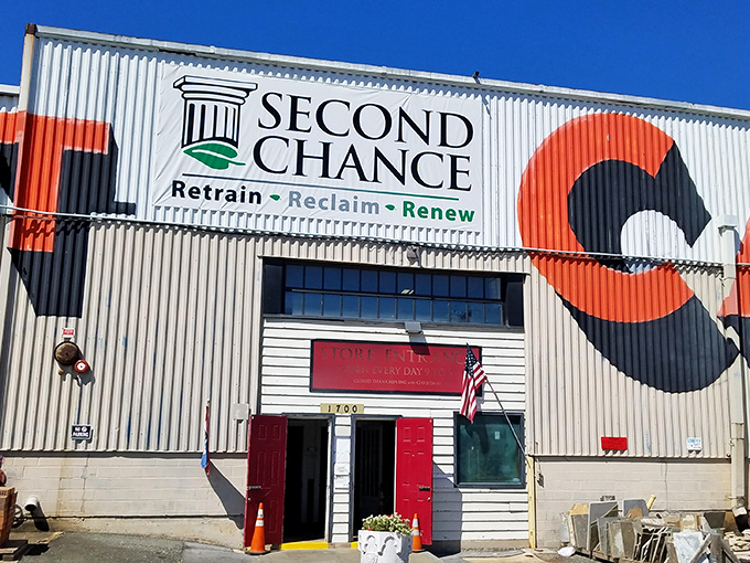 The iconic red doors and corrugated metal facade of Second Chance stand as a beacon of hope for both furniture and the people who give it new life.