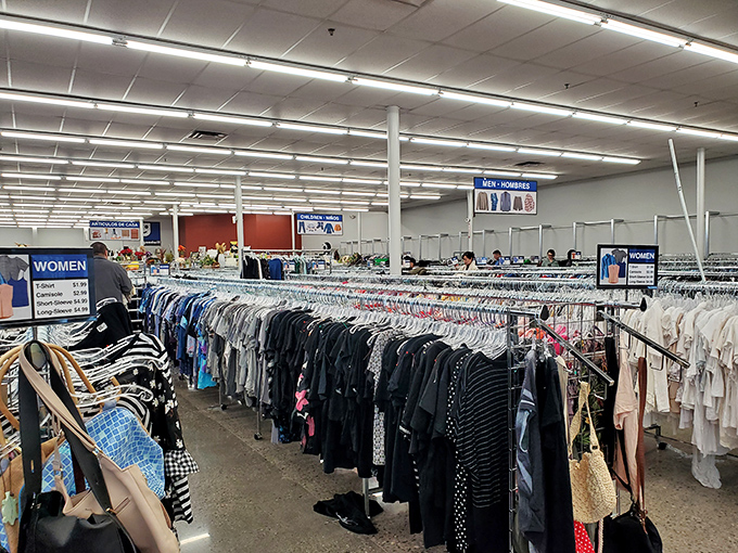 Treasure hunting begins here! Row after row of clothing racks stretch toward the fluorescent horizon, each hanger potentially hiding your next favorite outfit.