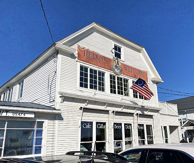 Classic Vermont charm in white clapboard perfection. Hero's Welcome stands proudly against the blue sky, promising treasures both edible and whimsical within.