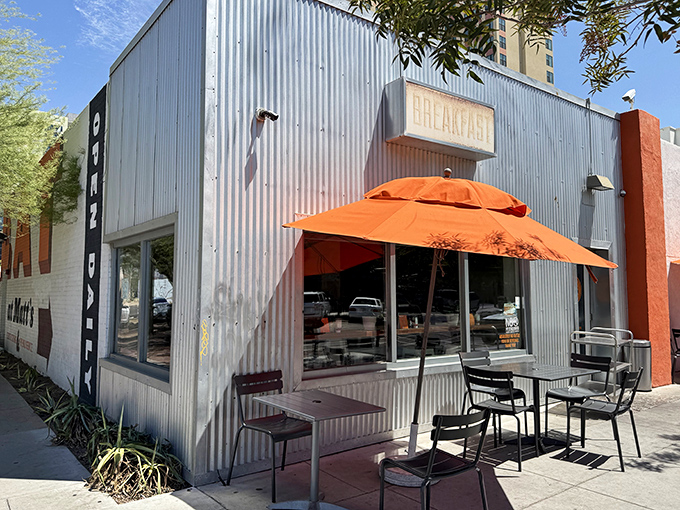 The corrugated metal exterior might not scream "culinary destination," but that orange umbrella beckons like a breakfast lighthouse in downtown Phoenix.