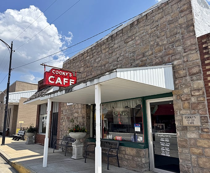 The iconic red Cooky's Cafe sign against rustic stone promises comfort food paradise in Golden City&mdash;a beacon for hungry travelers since 1942.