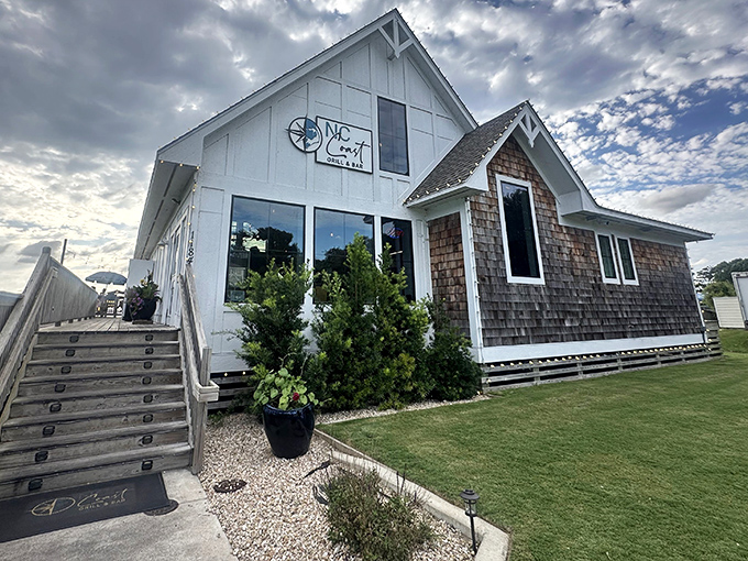 The coastal charm of NC Coast Grill & Bar beckons with its classic white clapboard and cedar shake exterior&mdash;architectural poetry that whispers "fresh seafood inside."
