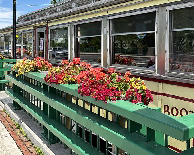 A vintage dining car with a splash of color &ndash; vibrant flower boxes line the green railings of this classic Worcester Lunch Car, a roadside time capsule.