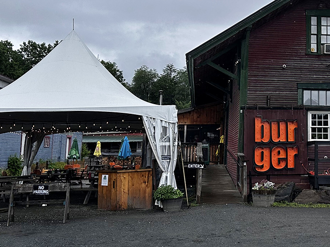 A white tent extends the dining space, creating an outdoor oasis where the aroma of wood-fired patties mingles with fresh mountain air.