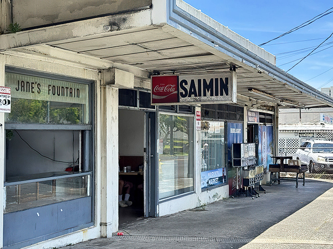 The unassuming exterior of Jane's Fountain, where faded signs and zero pretension promise authentic Hawaiian comfort food at prices from another era.