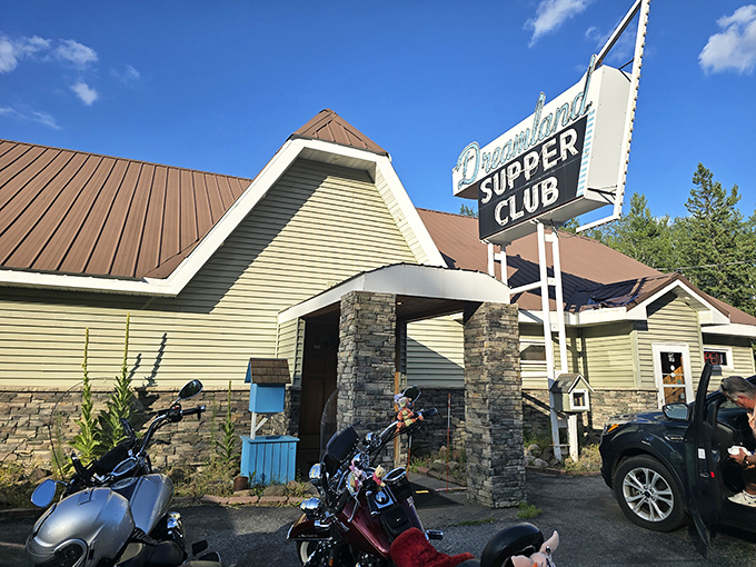 The iconic Dreamland sign beckons hungry travelers like a lighthouse for the famished. Wisconsin supper club perfection awaits behind those stone pillars.