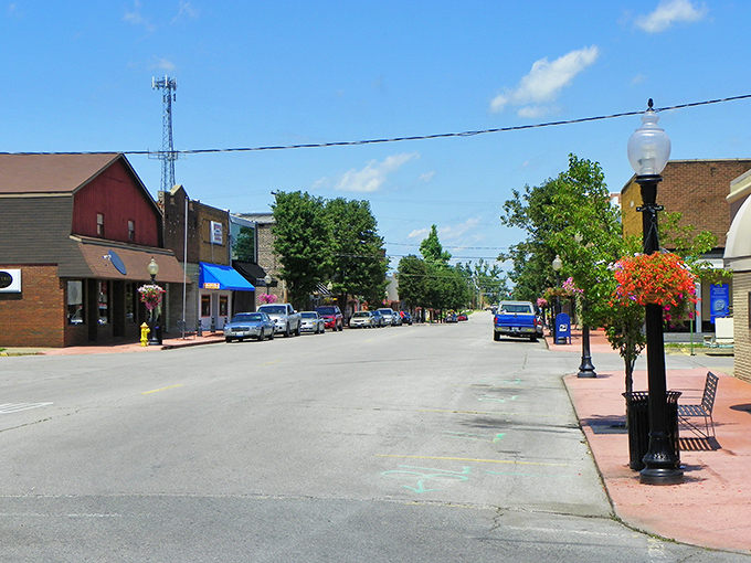 Colorful flower baskets adorn vintage lampposts along Metropolis's peaceful main street, where local shops welcome visitors with small-town charm.