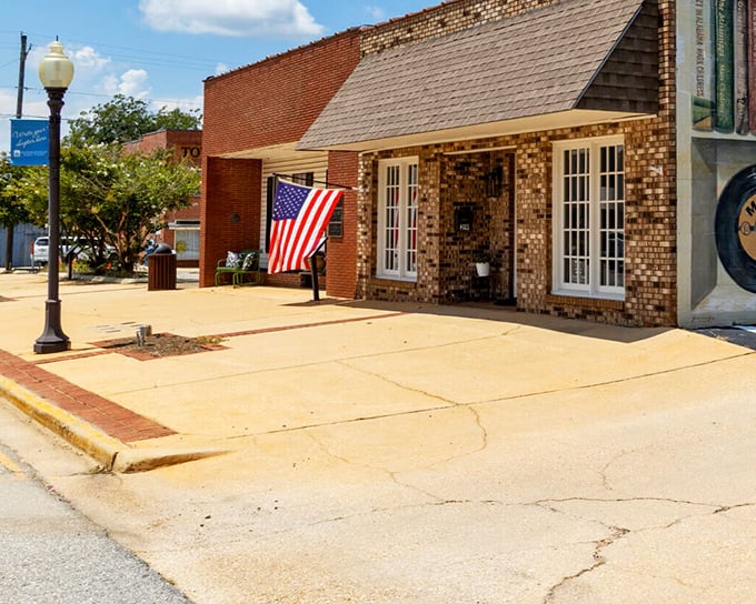 A charming brick storefront with an American flag proudly displayed along Monroeville's historic downtown, where literary heritage meets small-town hospitality.