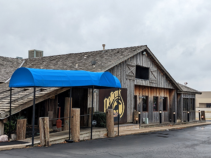 Rustic charm meets culinary excellence at Pelican's, where that blue awning serves as a beacon for hungry travelers seeking comfort food paradise.