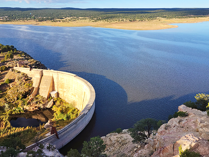 The engineering marvel meets nature's canvas at Bluewater Dam, where concrete curves cradle sapphire waters against New Mexico's endless horizon.