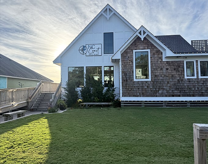 The coastal charm of NC Coast Grill & Bar beckons with its classic white clapboard and cedar shake exterior&mdash;beach house meets culinary haven.