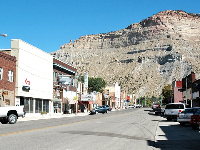Main Street unfolds like a living museum, where towering sandstone cliffs create a dramatic backdrop for Helper's charming downtown district.