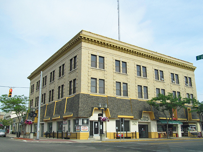 Downtown Ludington's historic architecture stands as a testament to Michigan craftsmanship, with the cream-colored building anchoring the corner like a ship's captain surveying the harbor.