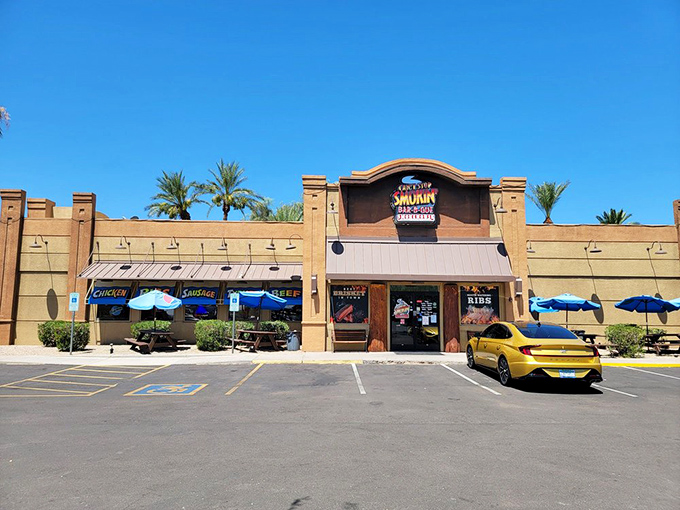 Blue skies and palm trees frame this temple of smoke, where picnic tables invite you to worship at the altar of slow-cooked perfection.