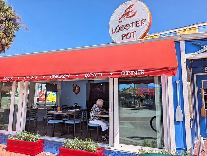 The iconic red awning and circular lobster sign beckon seafood lovers like a lighthouse guiding hungry sailors to shore.