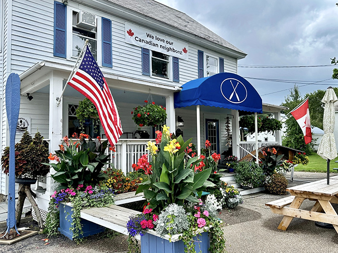 American flag on one side, flowers everywhere, and that iconic blue awning – this isn't just curb appeal, it's a full-blown curb romance.
