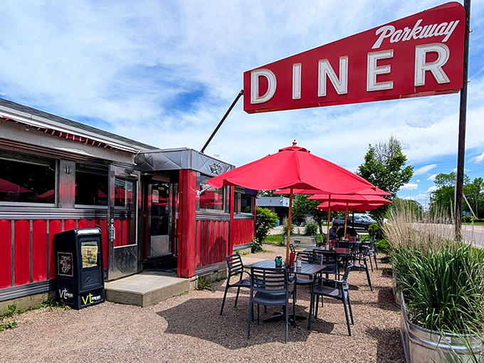 The classic red exterior of Parkway Diner stands like a time capsule of Americana, complete with those iconic red umbrellas beckoning hungry travelers to stop and stay awhile.