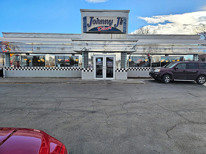 The classic blue and white checkerboard exterior of Johnny J's Diner stands as a beacon of breakfast hope on Casper's horizon, promising comfort food salvation inside.