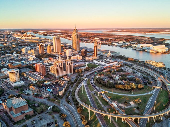 Sunset bathes Mobile in golden light, transforming the RSA Tower into a beacon while the circular highway embraces downtown like a protective hug.