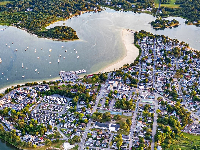 Aerial magic reveals Onset Beach's perfect crescent, where boats dot the bay like confetti and streets form a patchwork quilt of coastal living.