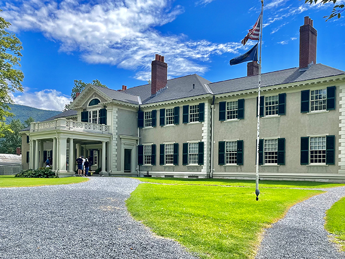 The grand entrance to Hildene stands proudly against Vermont's blue sky, welcoming visitors to step into the Lincoln family's storybook world.