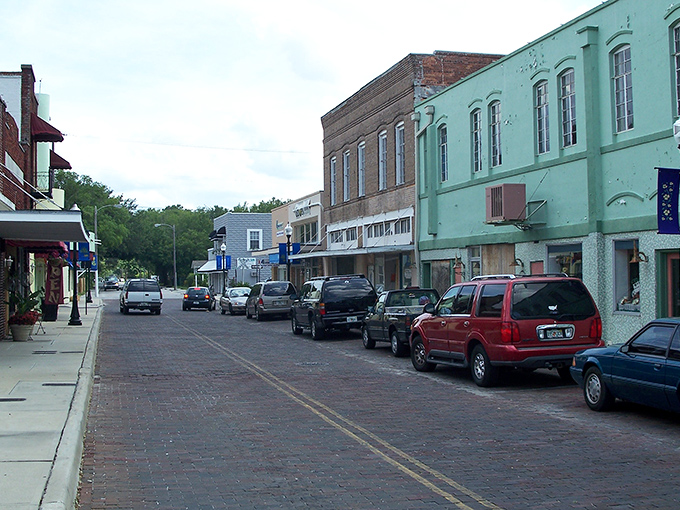 Pastel-colored storefronts line the brick-paved main street, creating a nostalgic palette that Instagram filters try desperately to replicate.
